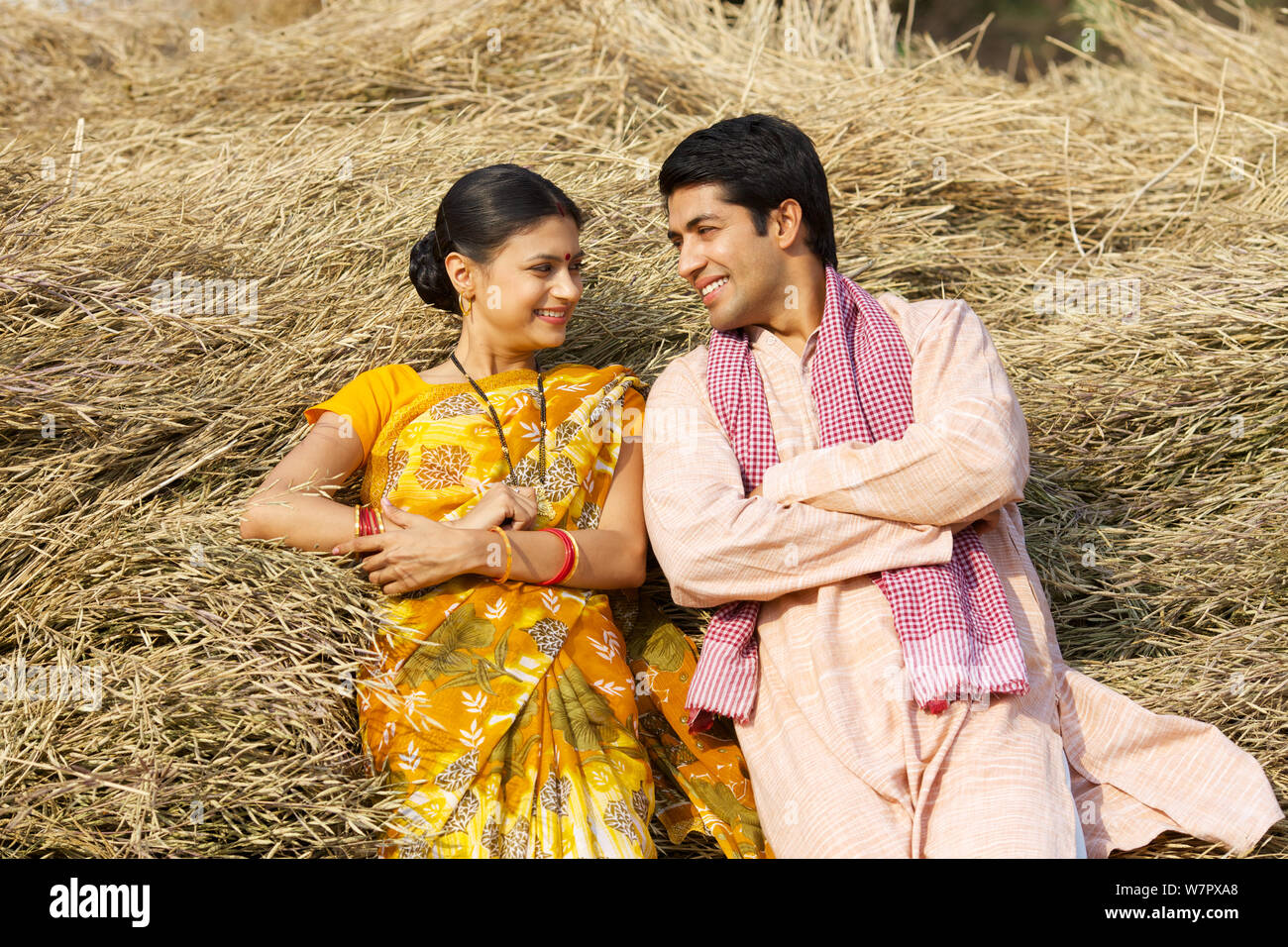 Rural couple lying against harvested crop Stock Photo - Alamy