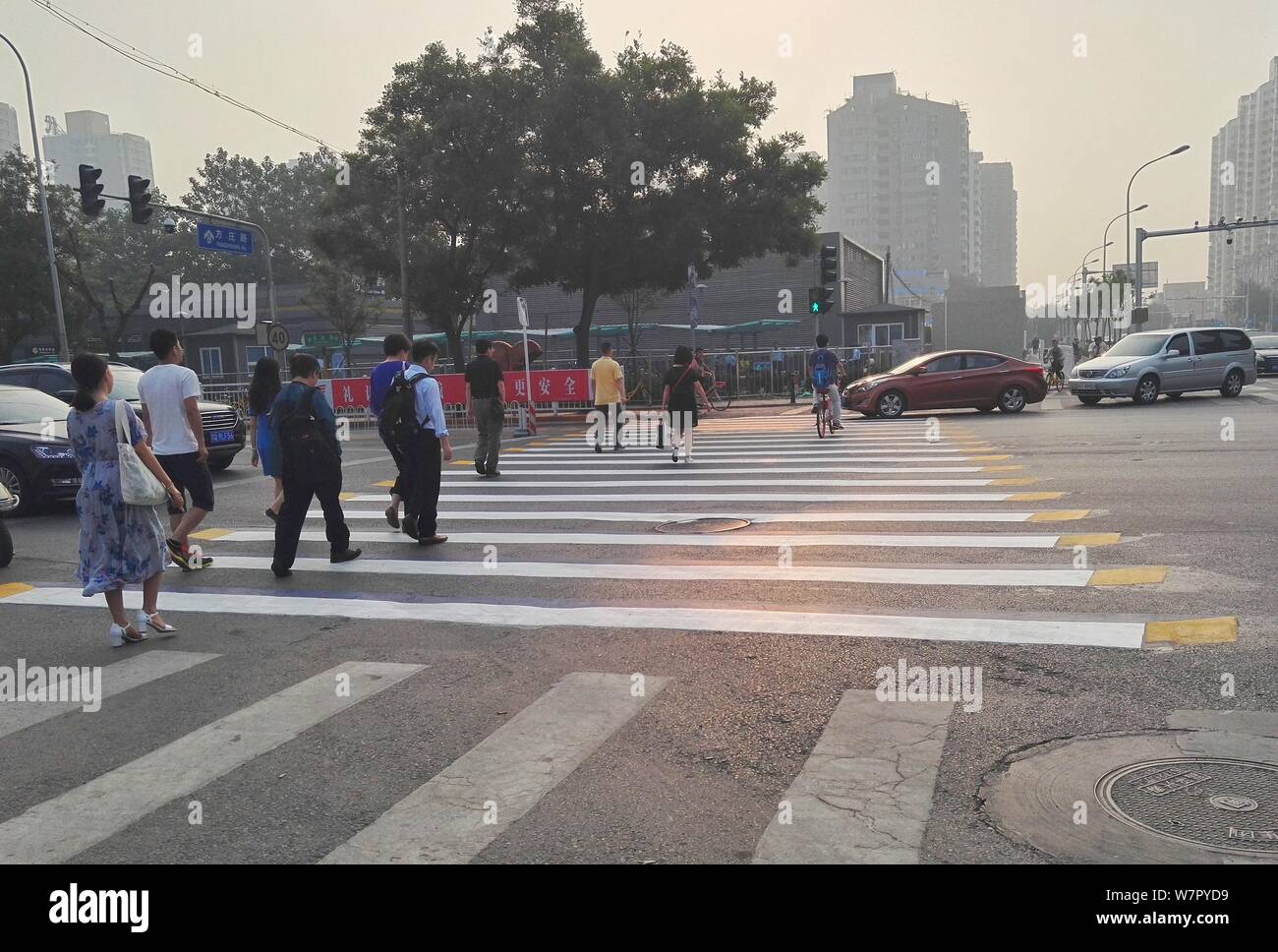 Pedestrians walk on a 3D zebra crossing at Fengtai district in Beijing ...