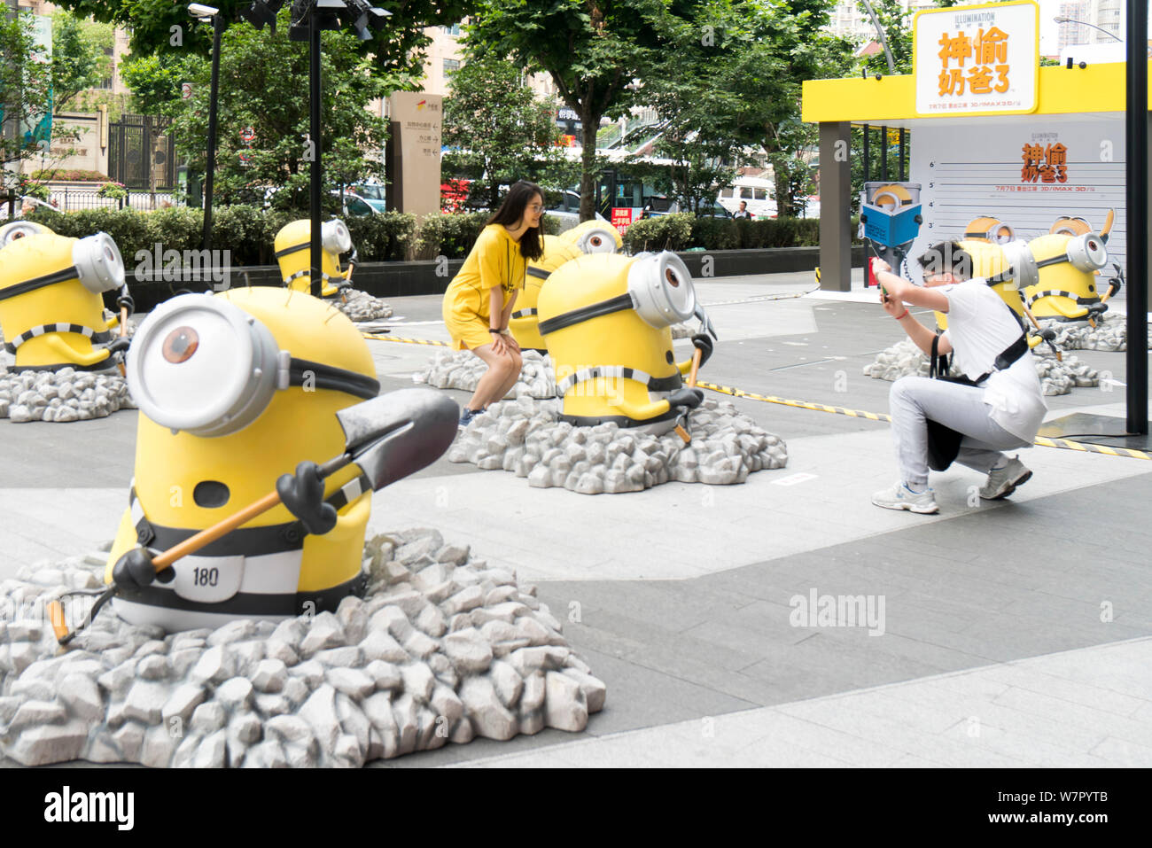 A Chinese citizen takes photos with Minions-shaped sculptures armed ...