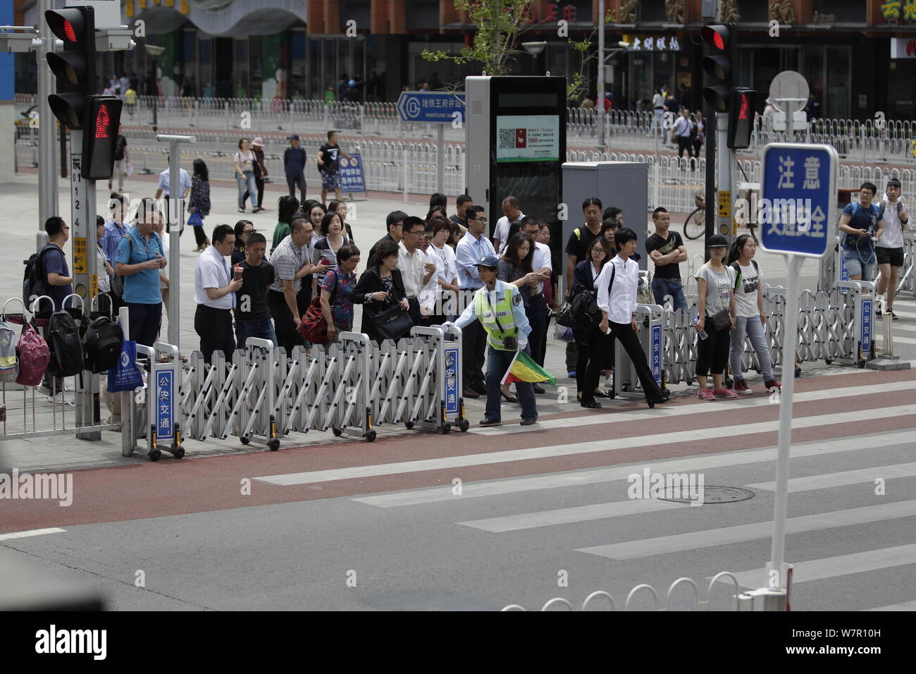 A traffic management assistant closes a gate to prevent pedestrians ...