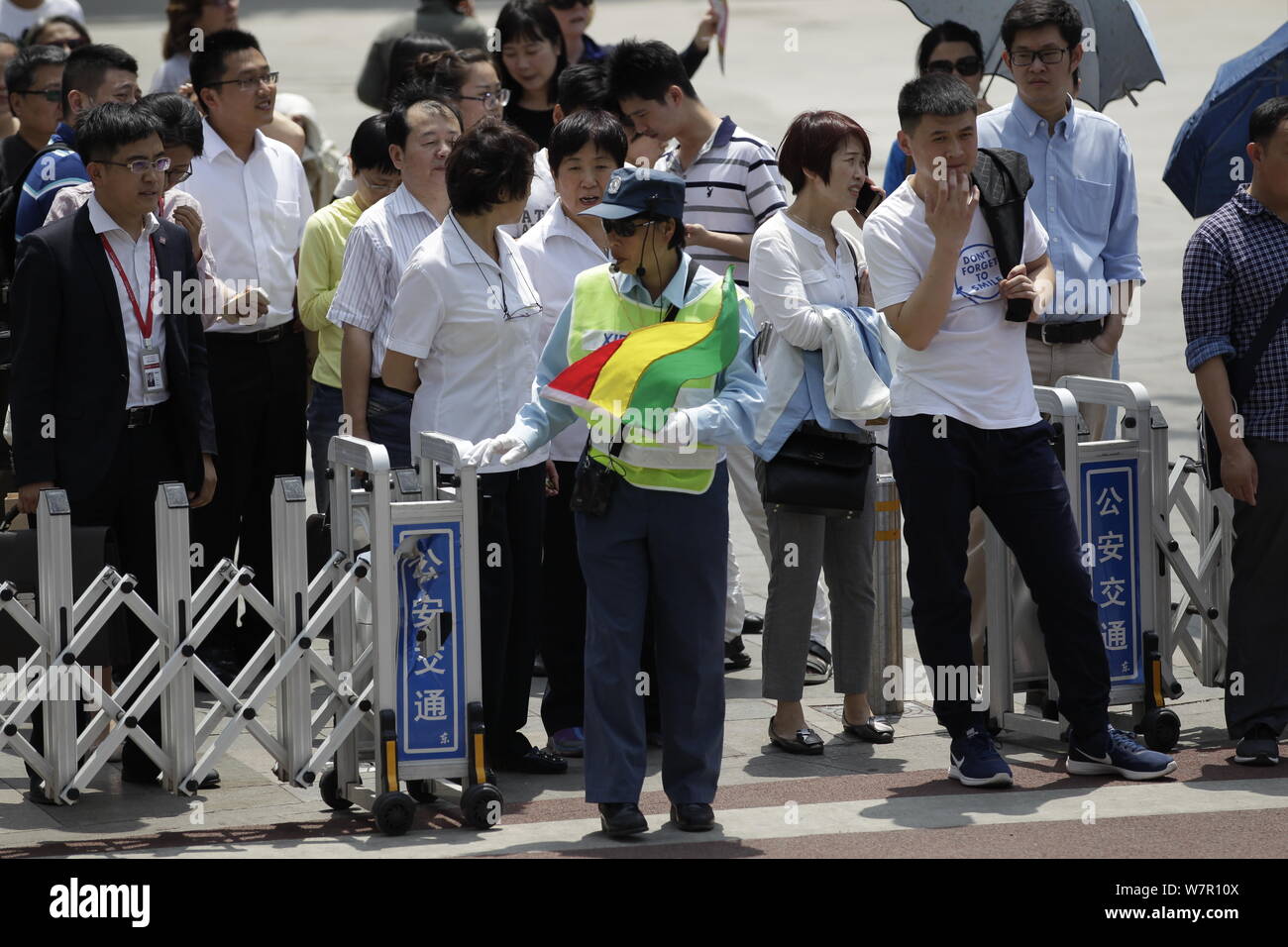 A traffic management assistant closes a gate to prevent pedestrians ...
