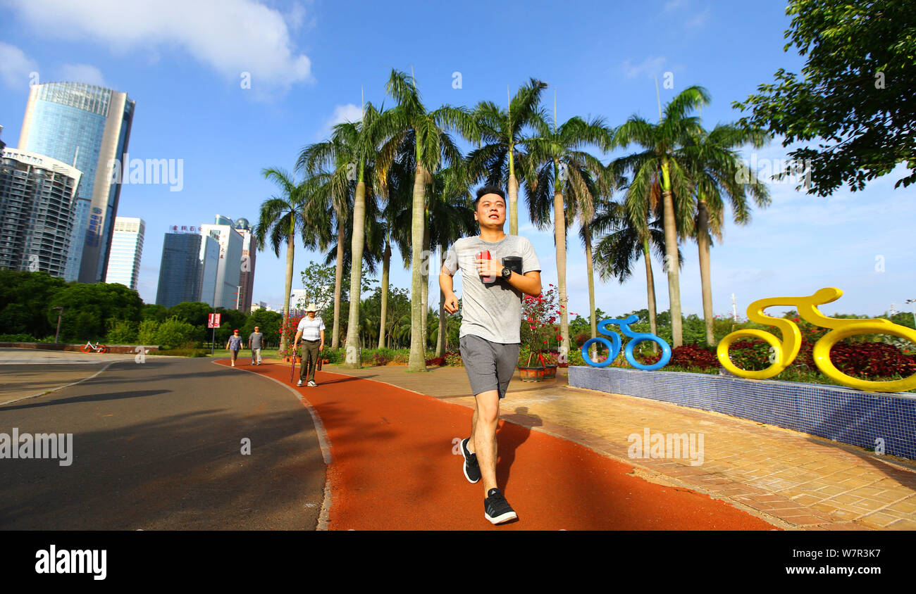 A Chinese running enthusiast jogs in Wanlvyuan Park in Haikou city ...