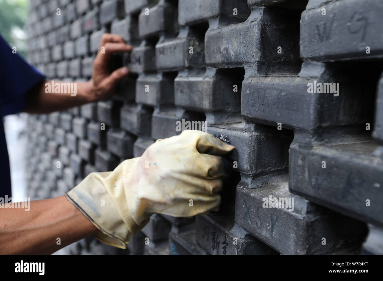 A Chinese cleaner scrubs graffiti off a wall left by unruly visitors at ...
