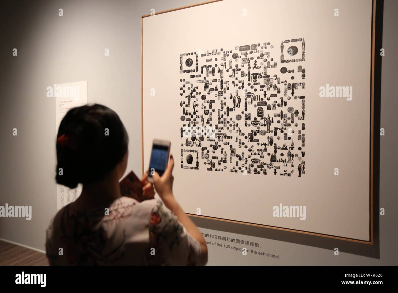 A visitor looks at the QR code composed of the 100 objects in the ...
