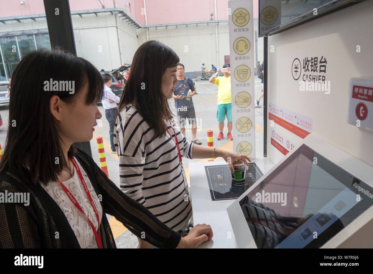 A customer uses her smartphone to pay for her purchase at the city's ...