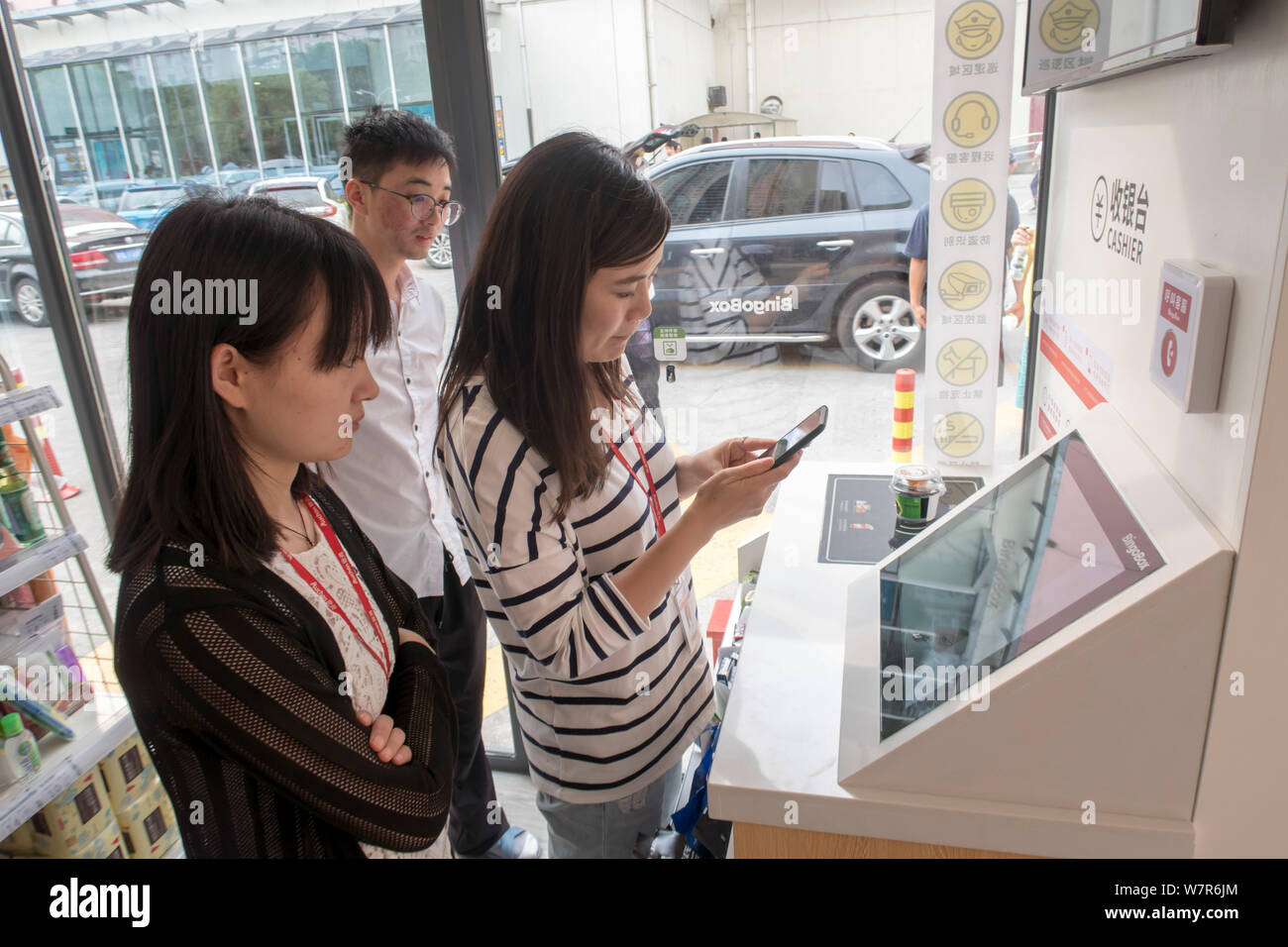 A customer uses her smartphone to pay for her purchase at the city's ...