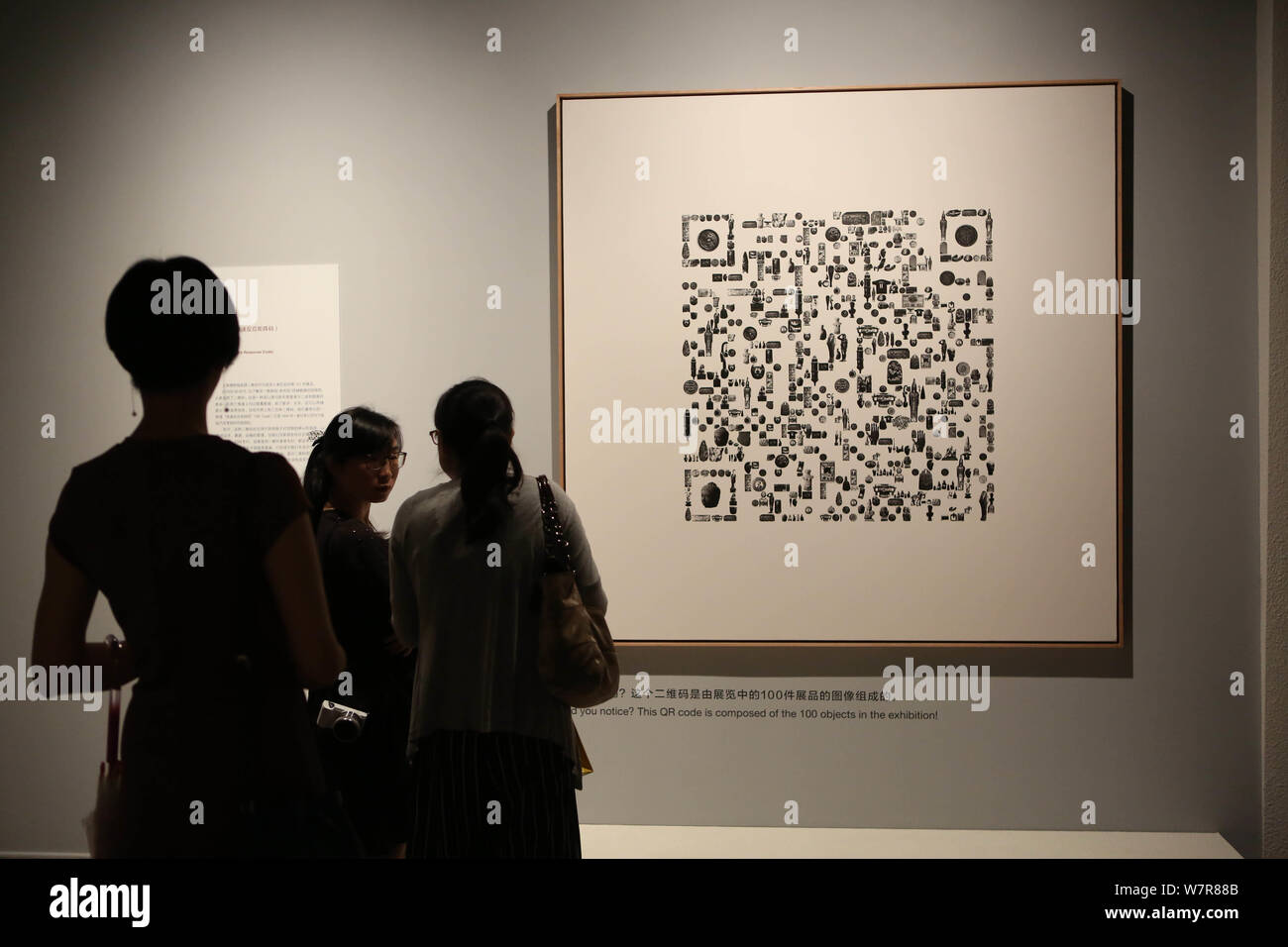 Visitors look at the QR code composed of the 100 objects in the ...