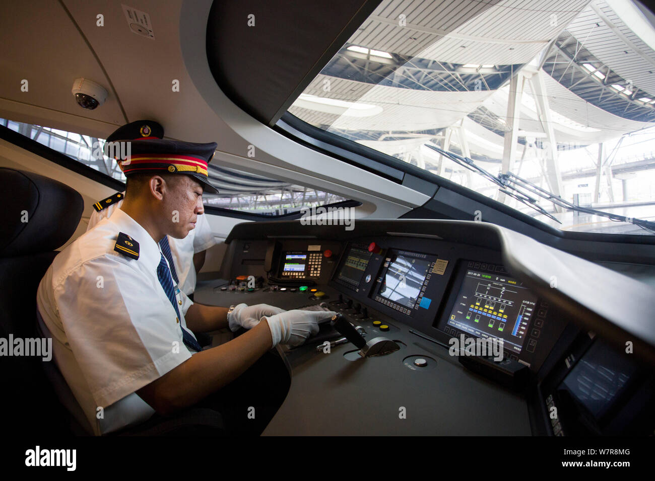 Drivers are seen in the cockpit of a "Fuxing" high speed bullet train ...