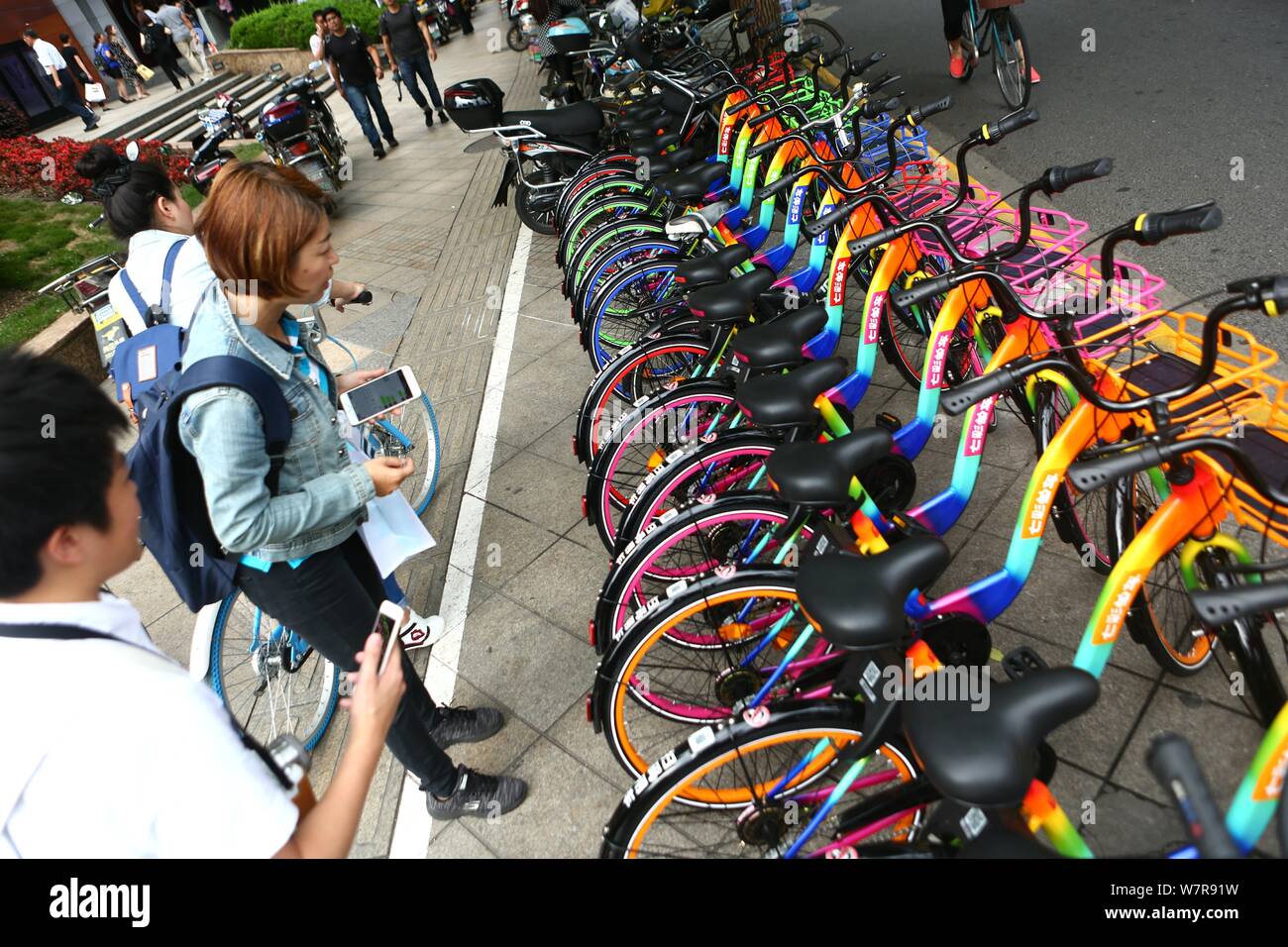 Local residents look at seven-colored shared bicycles of Chinese bike ...