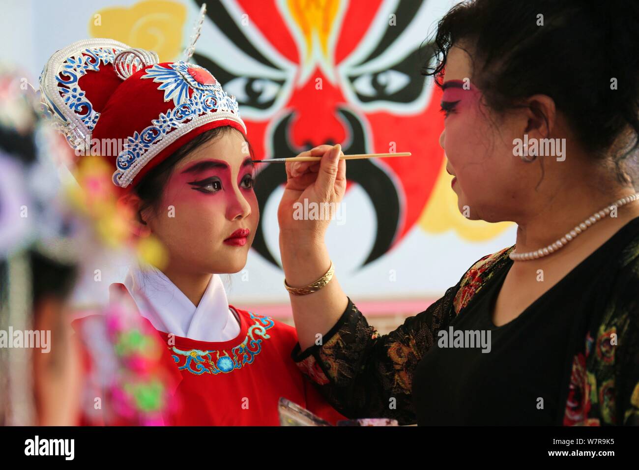A pupil from Binhe primary school finishes her elaborate Yu Opera or ...