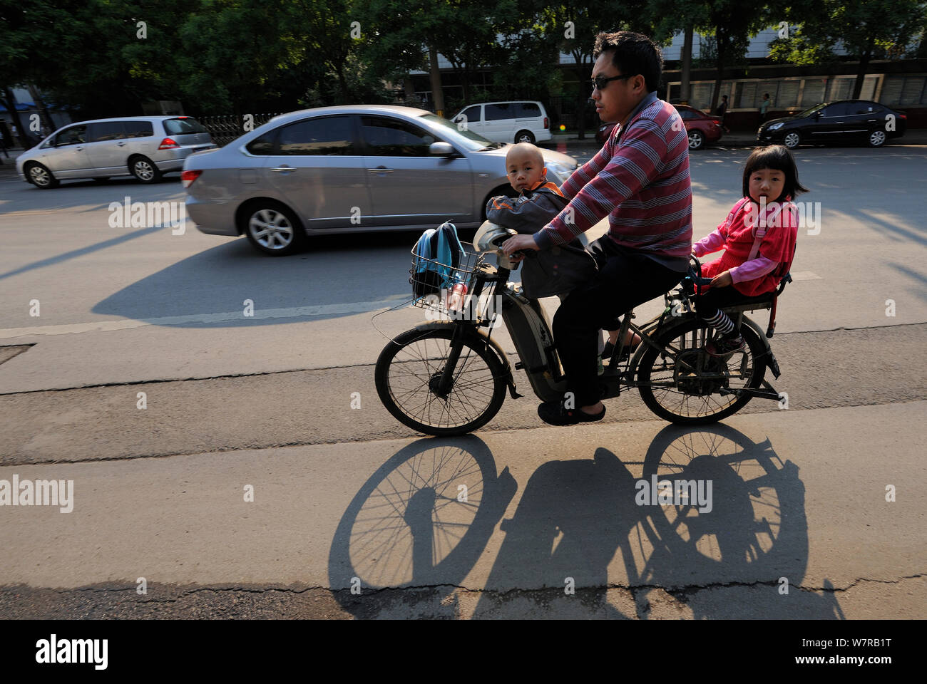 Man on bicycle commuting to work and the kids to school / daycare ...