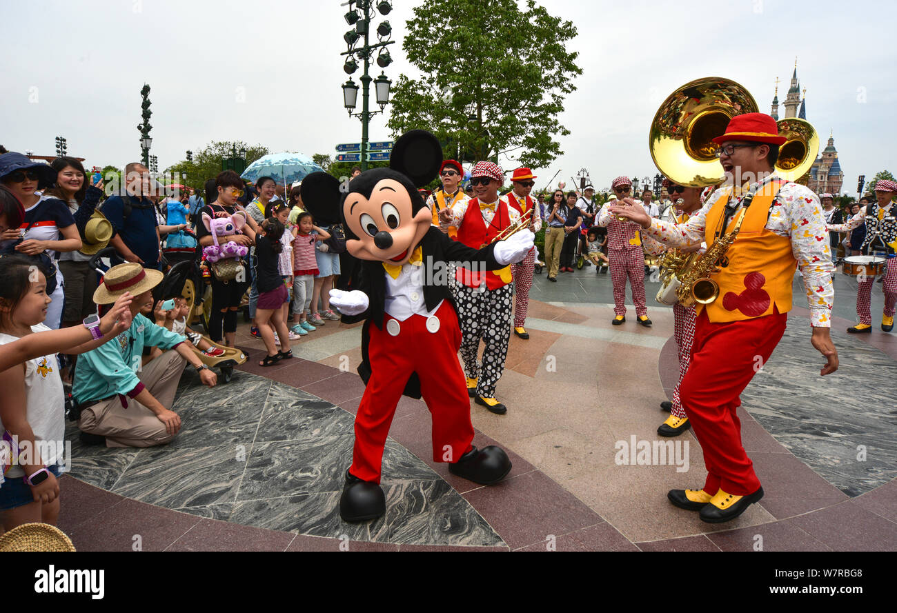 An entertainer dressed in a Mickey Mouse costume performs during a ...