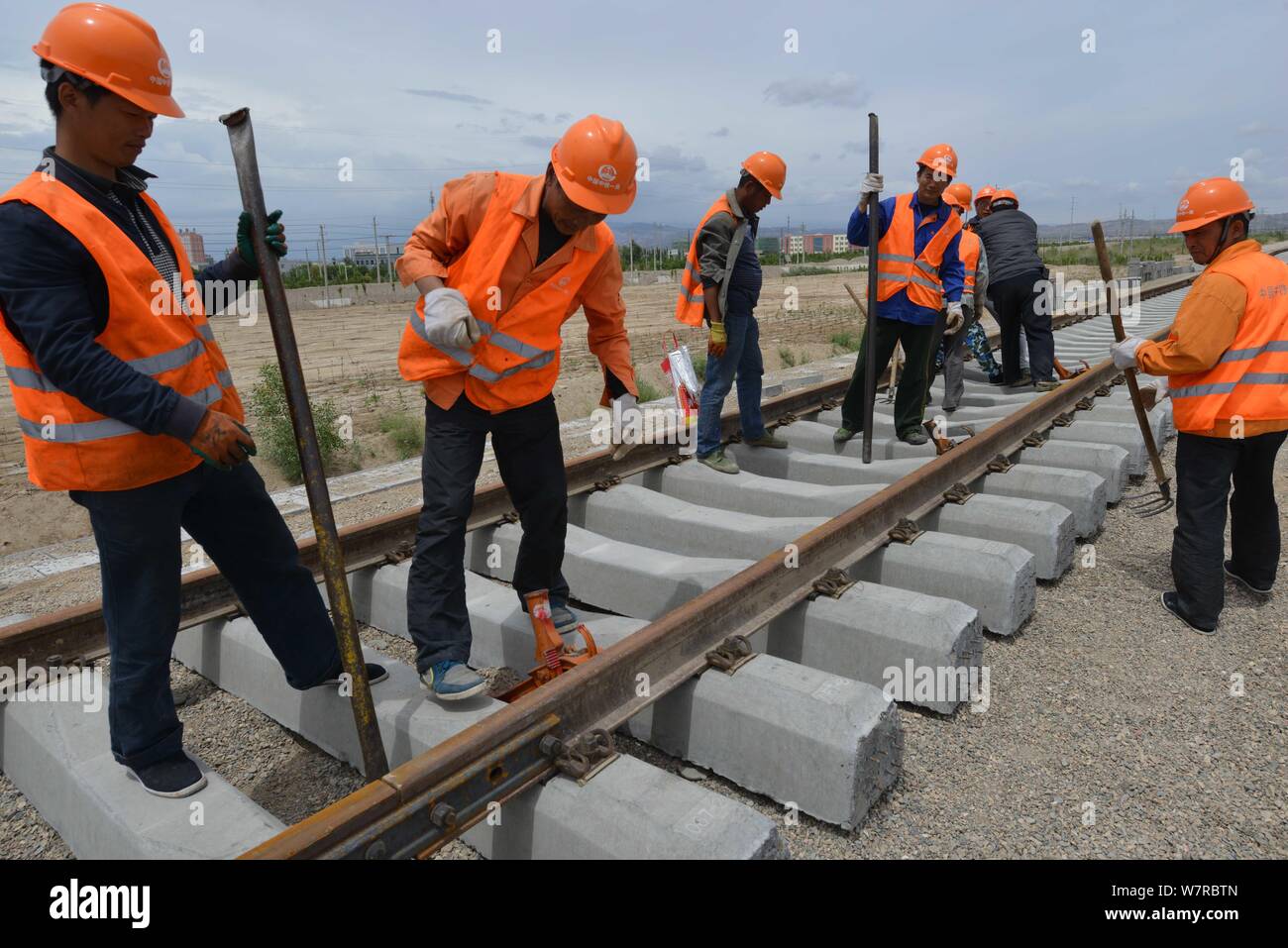 Chinese workers labor at the construction site to lay the tracks on the ...