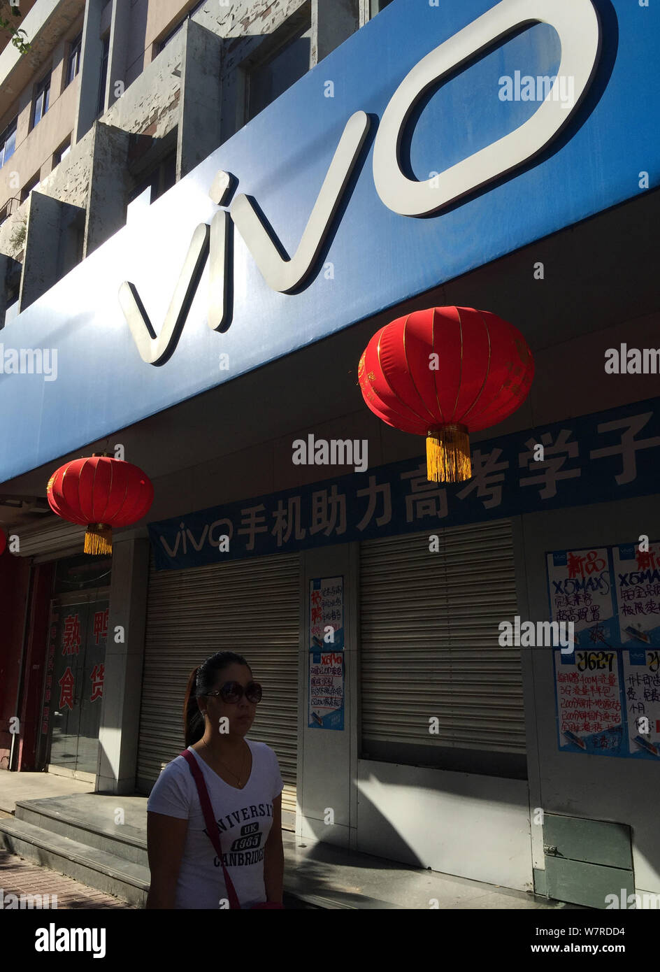 --FILE--A pedestrian walks past a mobile phone store of Vivo in Beijing ...