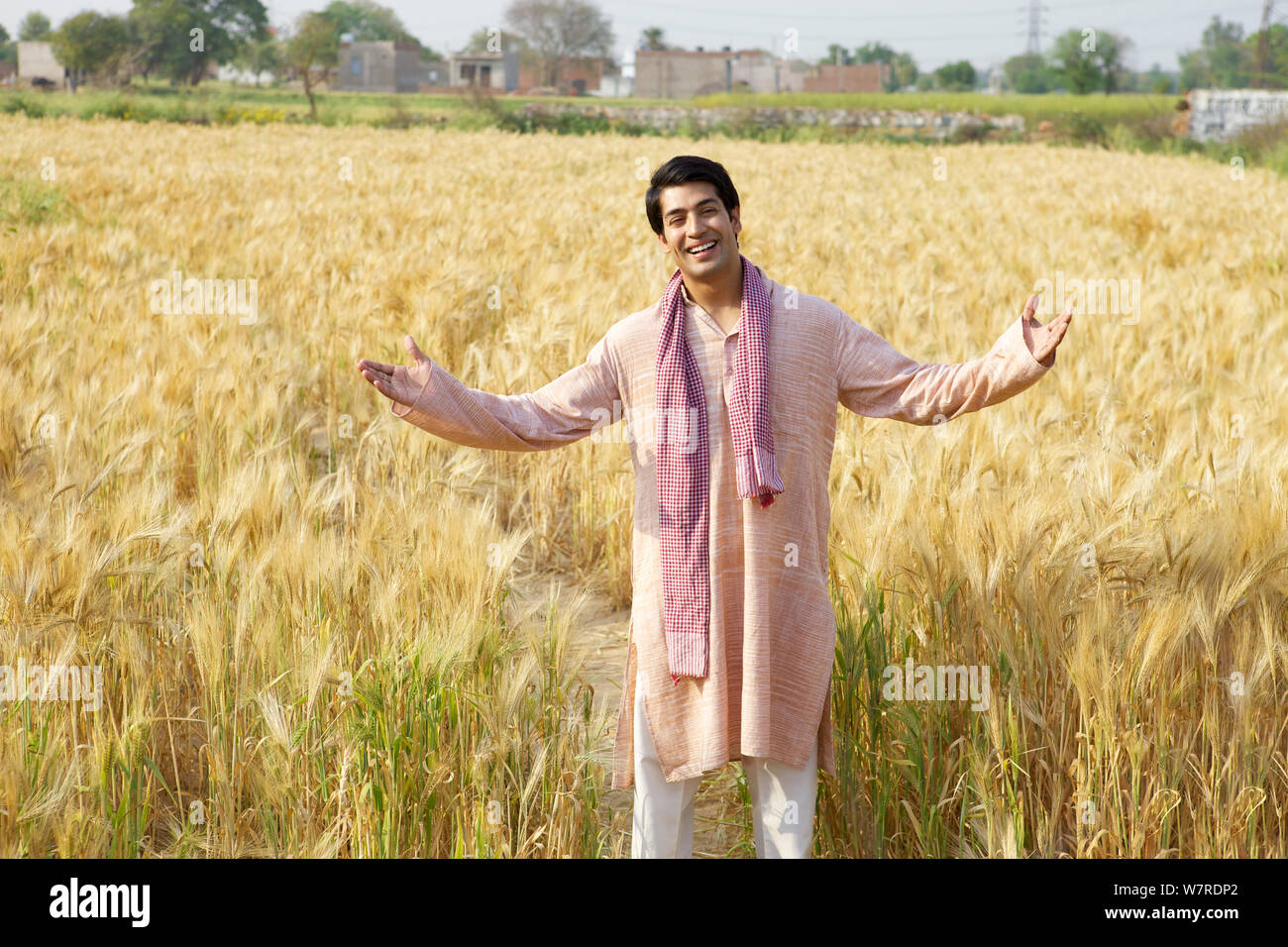 Farmer showing his field and smiling Stock Photo - Alamy