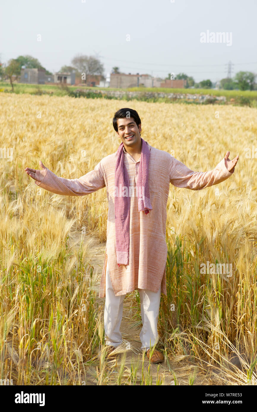Farmer showing his field and smiling Stock Photo - Alamy