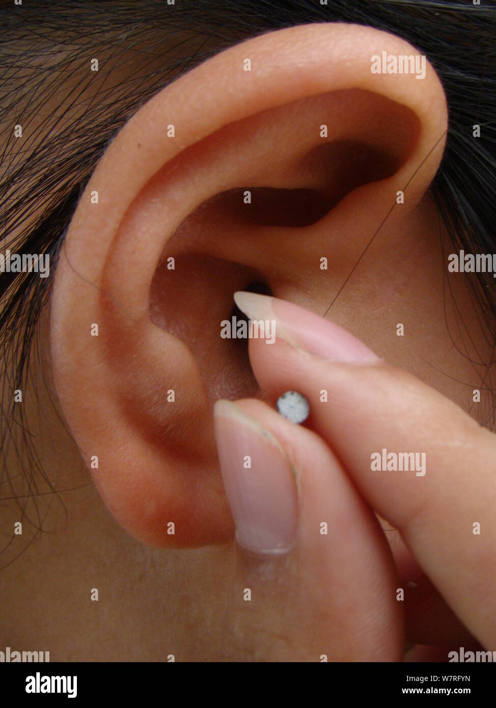 A Chinese examinee shows how to use a mini cheating device during the ...