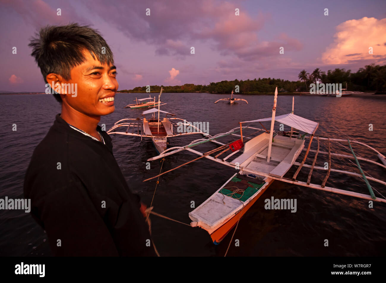 Portrait of man holding mooring rope of bangka boat, Jao Island ...