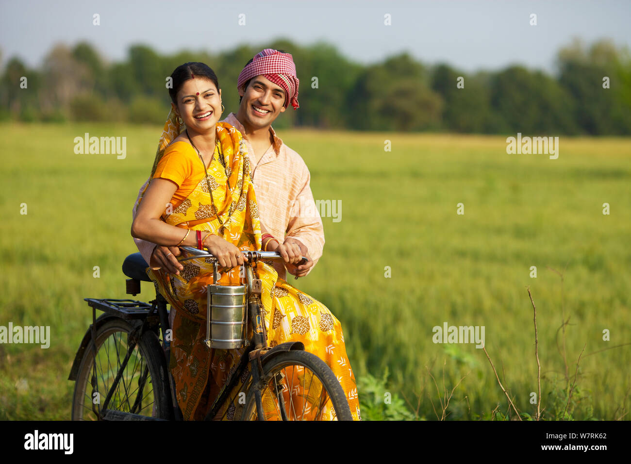 Rural couple riding on a bicycle and smiling Stock Photo - Alamy