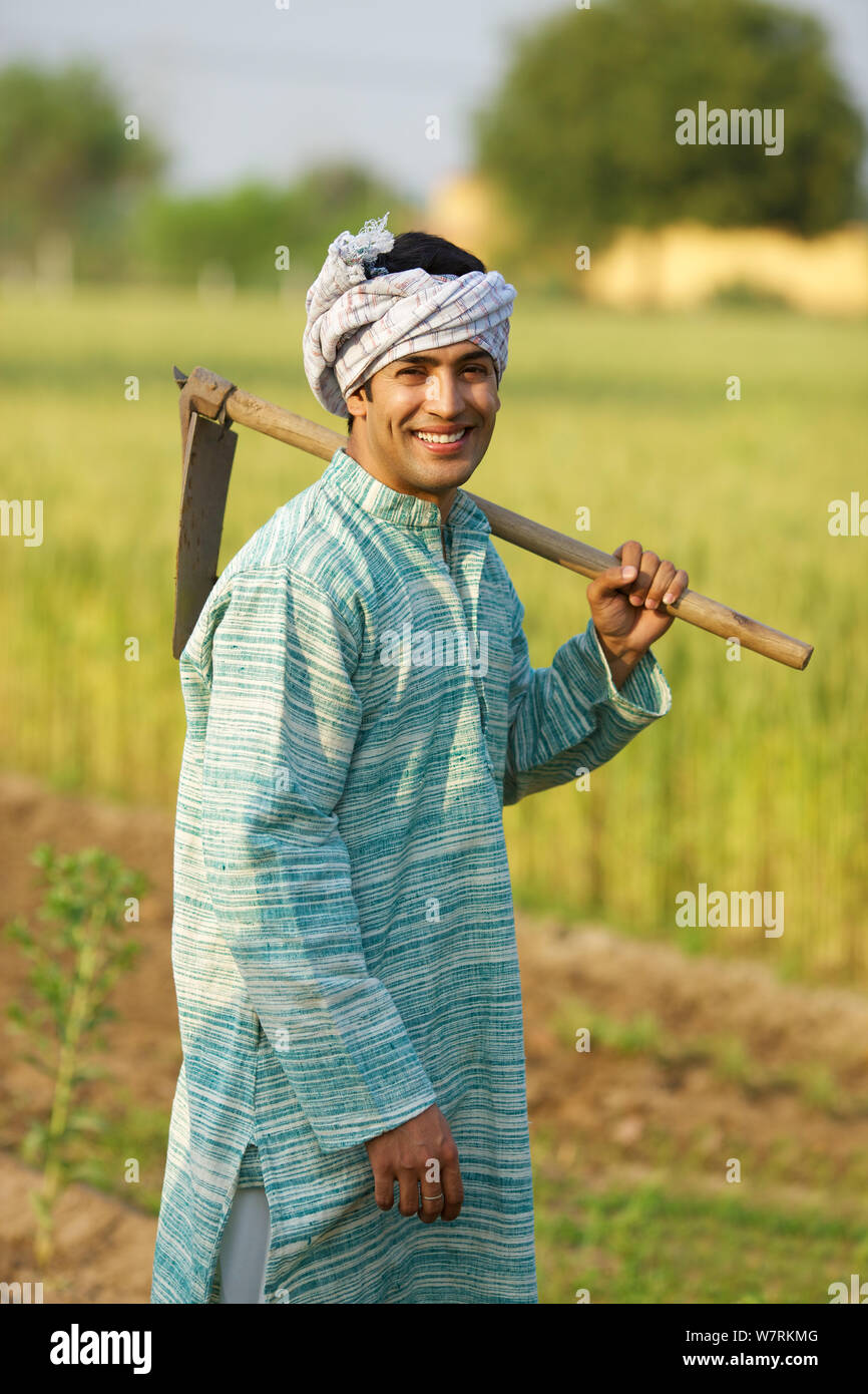 Farmer with a hoe standing in a field Stock Photo - Alamy