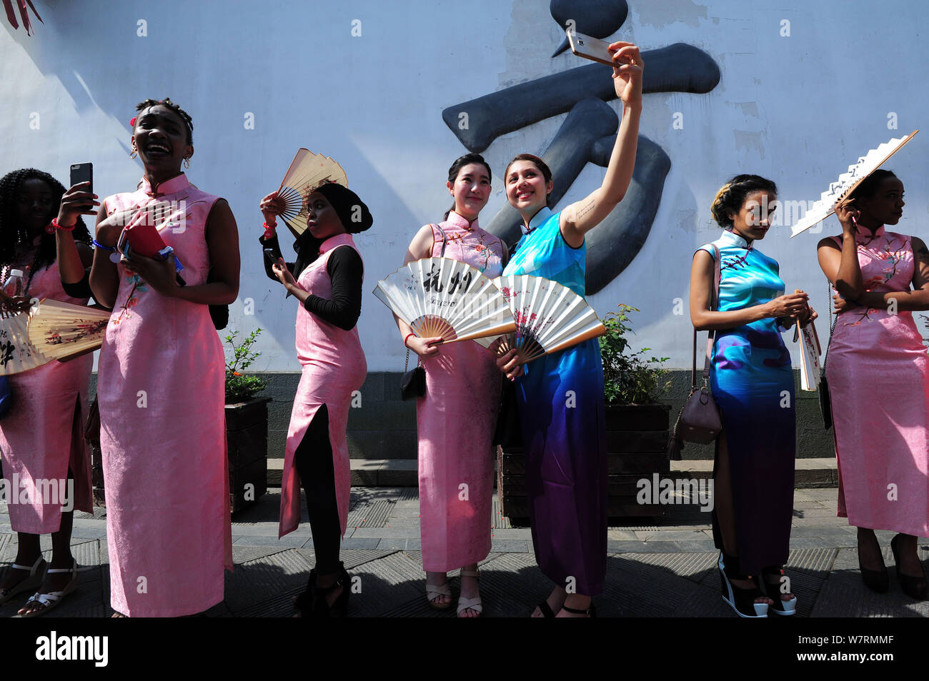 Women from different countries dressed in cheongsam, also known as ...