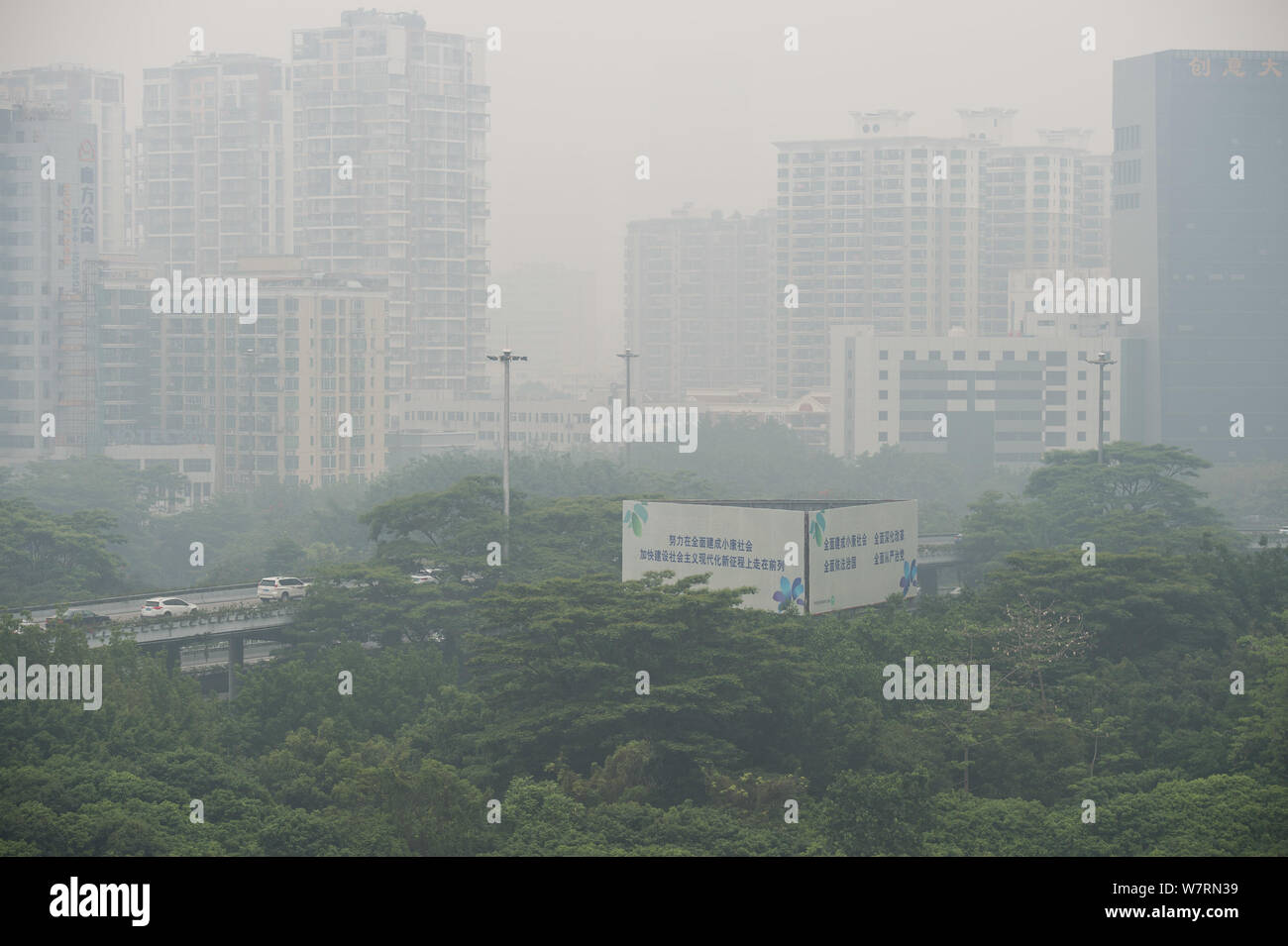 High-rise buildings and skyscrapers are seen vaguely in heavy smog in ...
