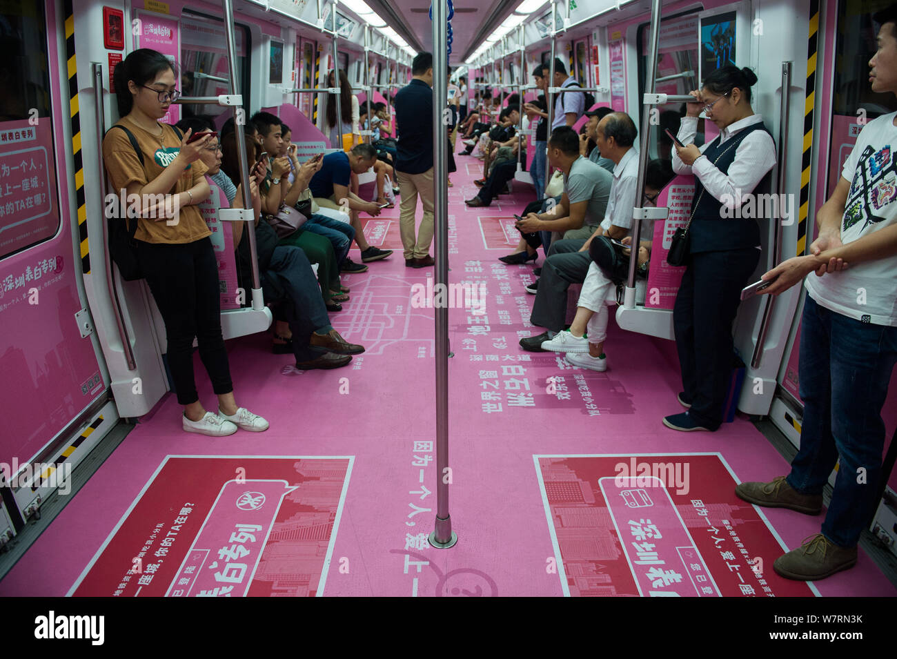 Chinese commuters are pictured in a subway train featuring pink ...