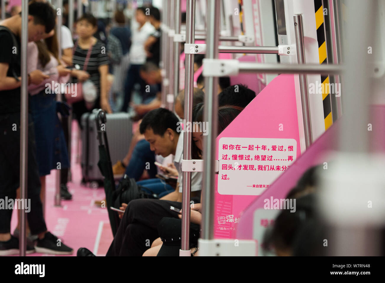 Chinese commuters are pictured in a subway train featuring pink ...