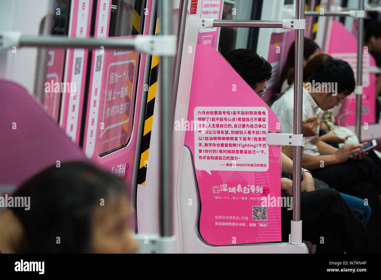 Chinese commuters are pictured in a subway train featuring pink ...