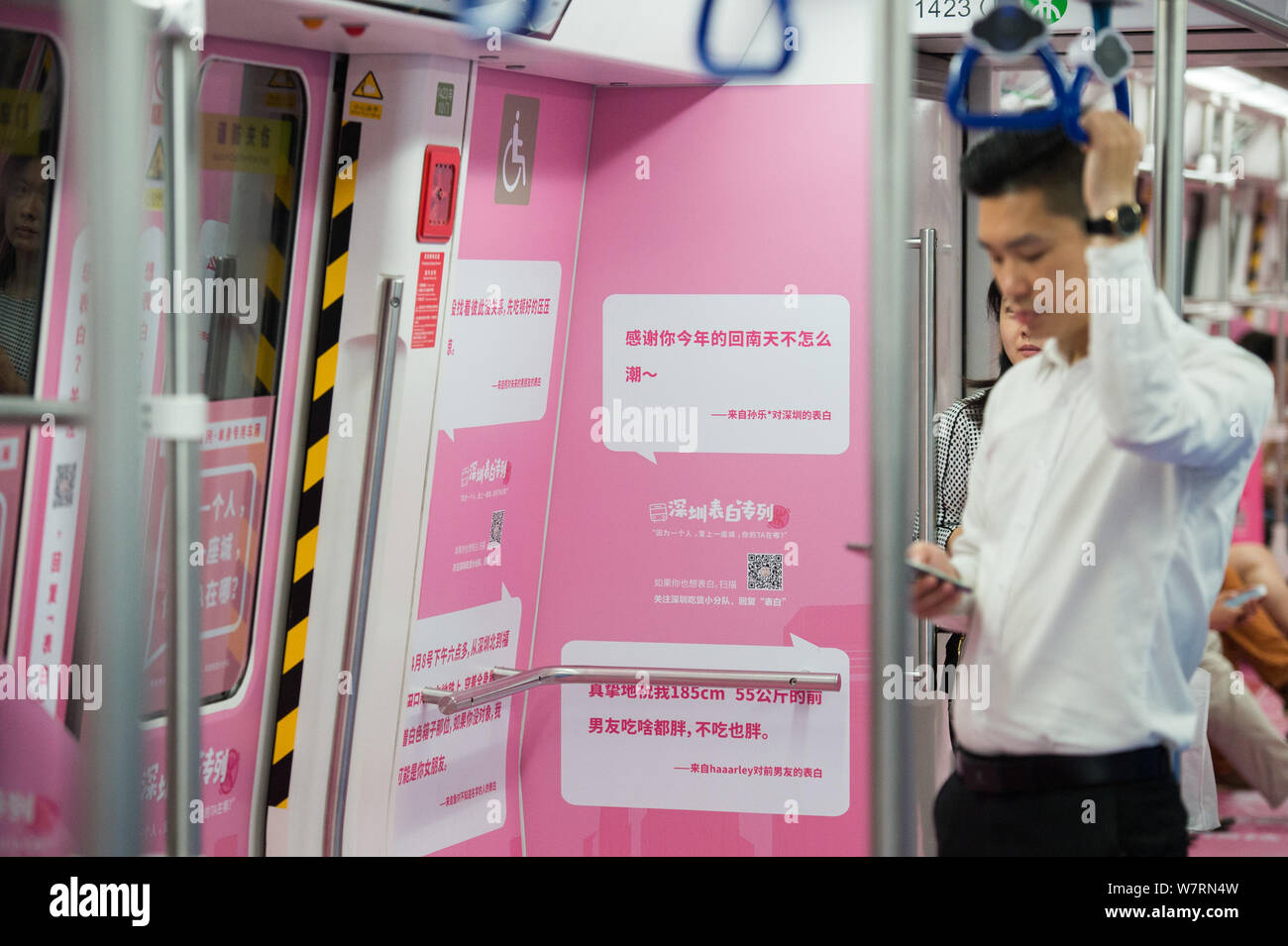 Chinese commuters are pictured in a subway train featuring pink ...