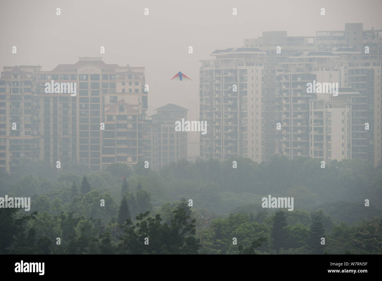 High-rise buildings and skyscrapers are seen vaguely in heavy smog in ...