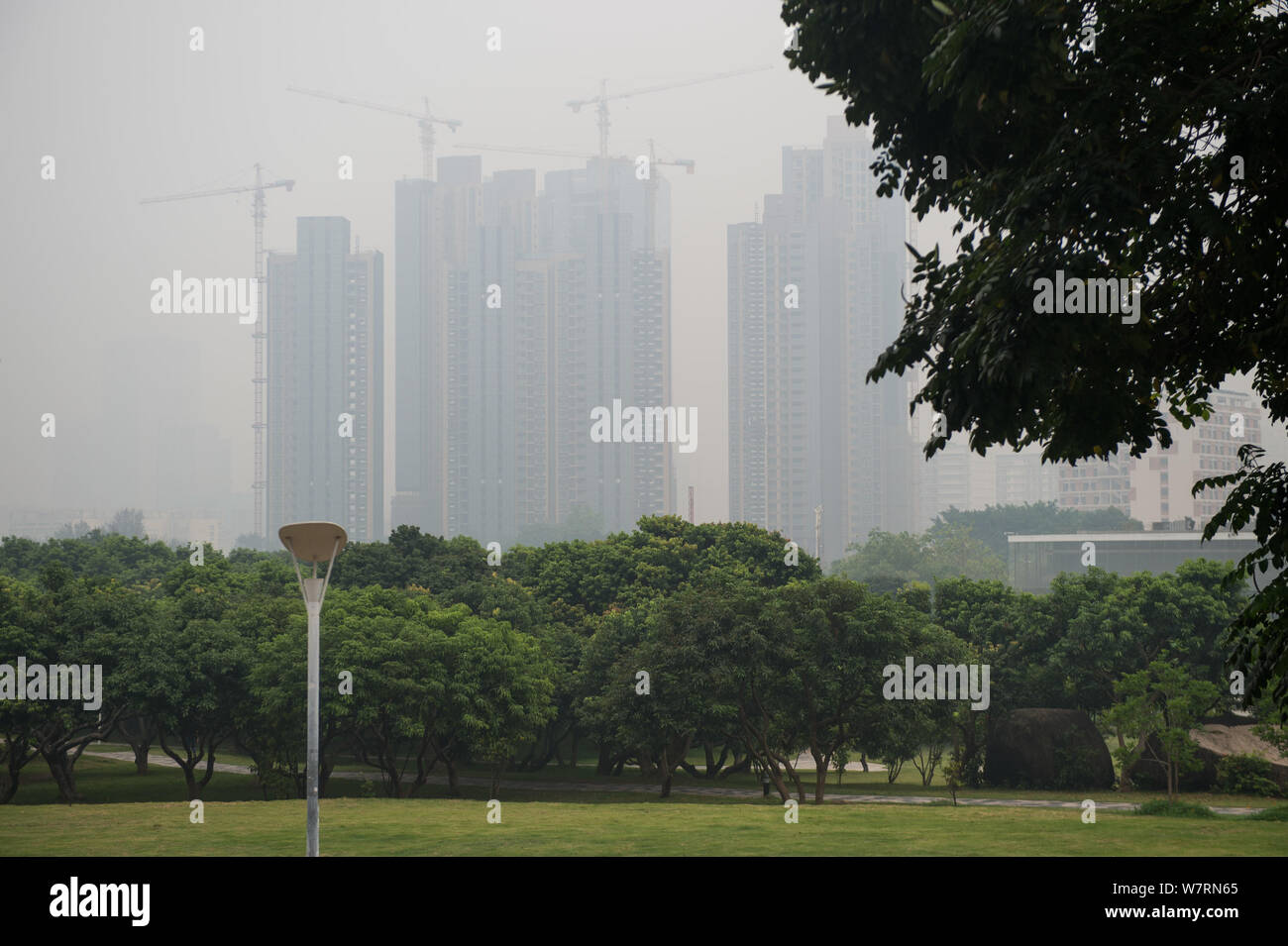 High-rise buildings and skyscrapers are seen vaguely in heavy smog in ...