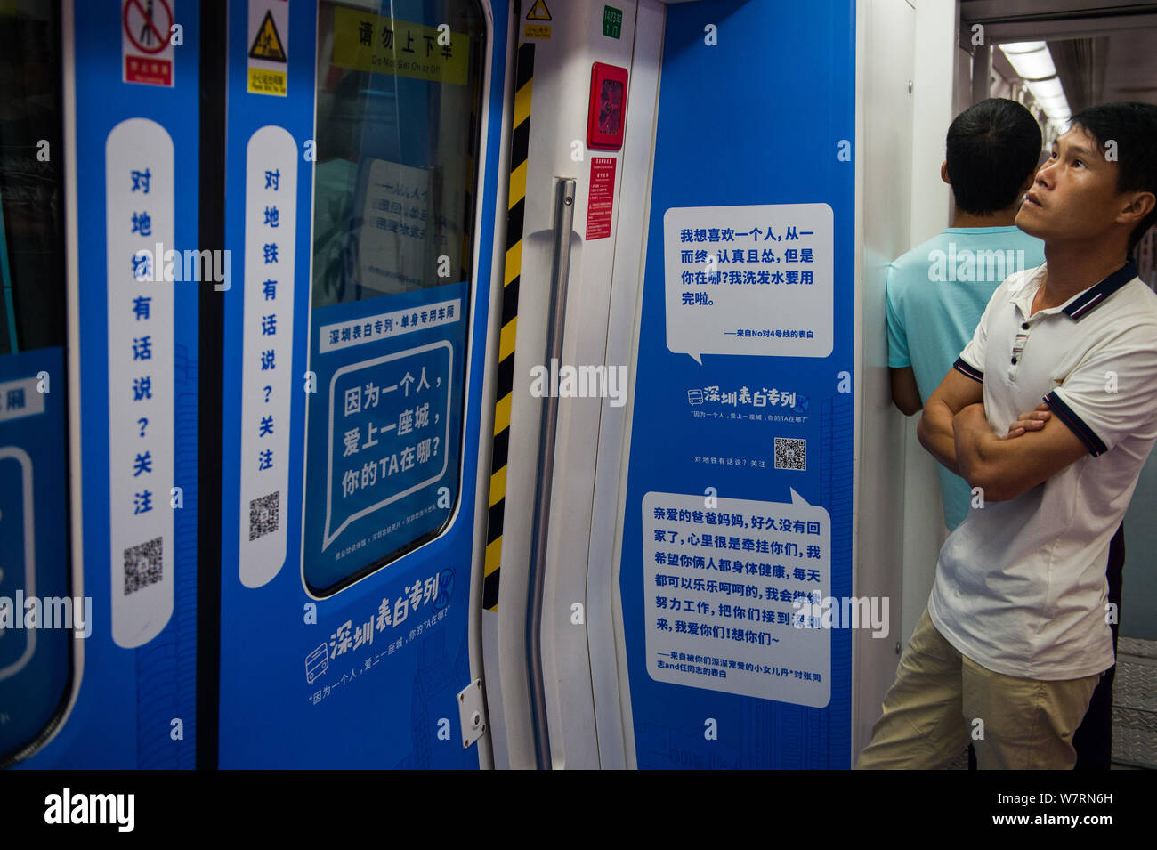 Chinese commuters are pictured in a subway train featuring blue ...