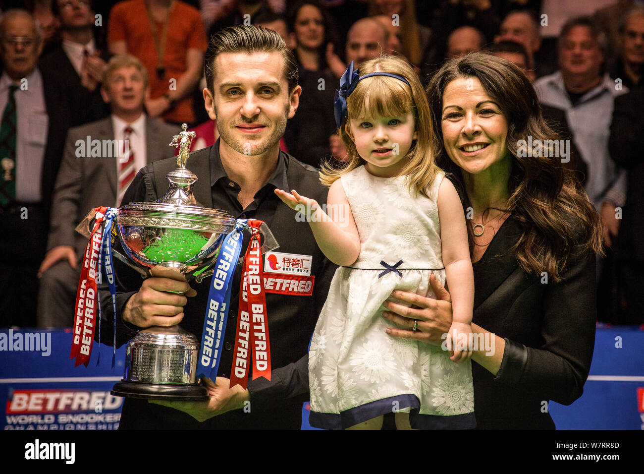 Mark Selby of England holding his trophy poses for photos with his wife ...