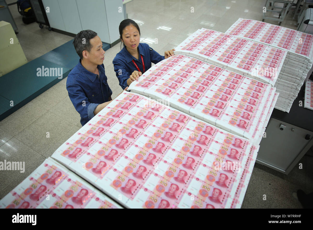 Chinese workers check RMB (renminbi) yuan notes on the assembly line at ...