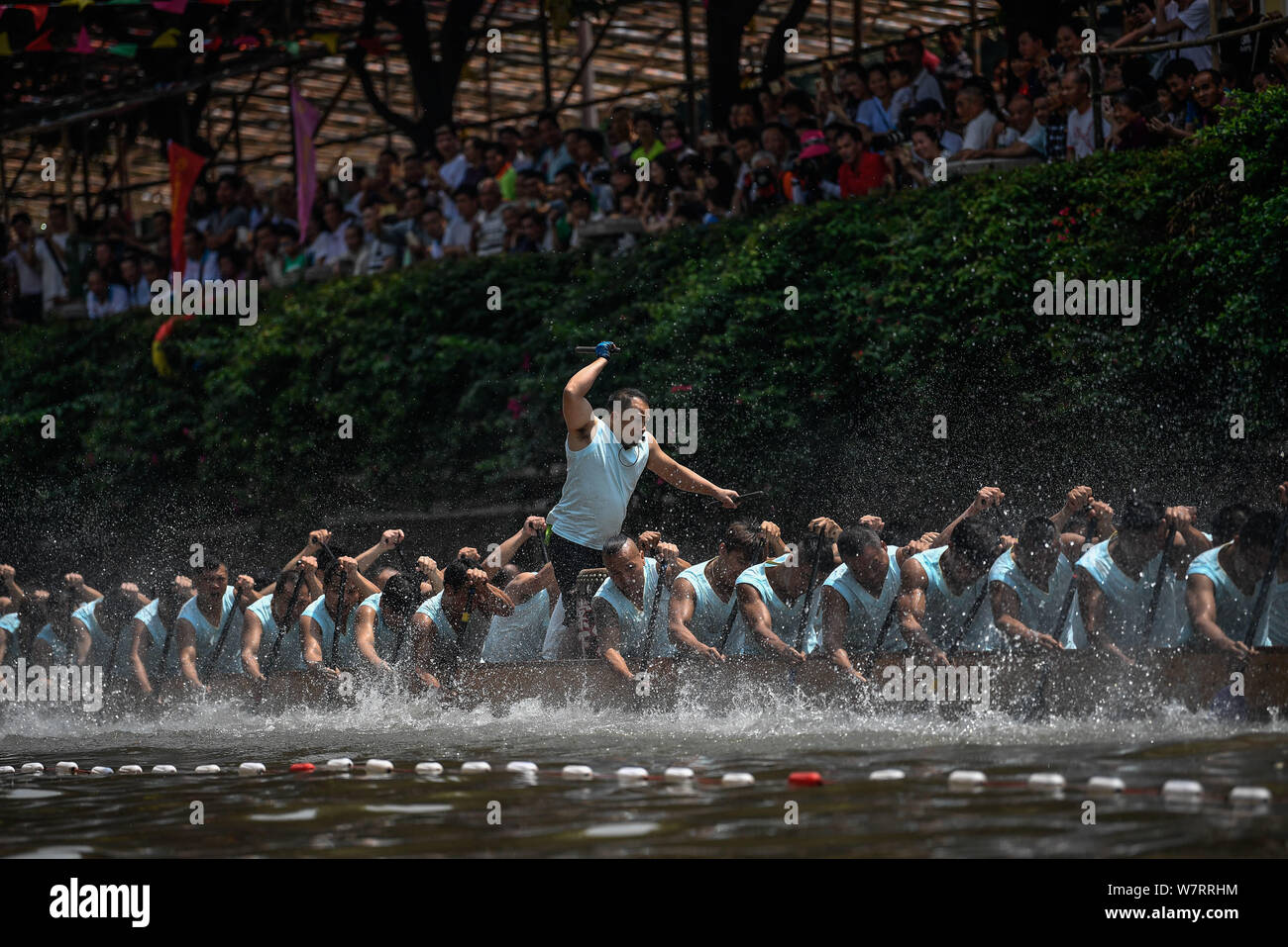 Participants compete in a dragon boat race on a river to celebrate the ...