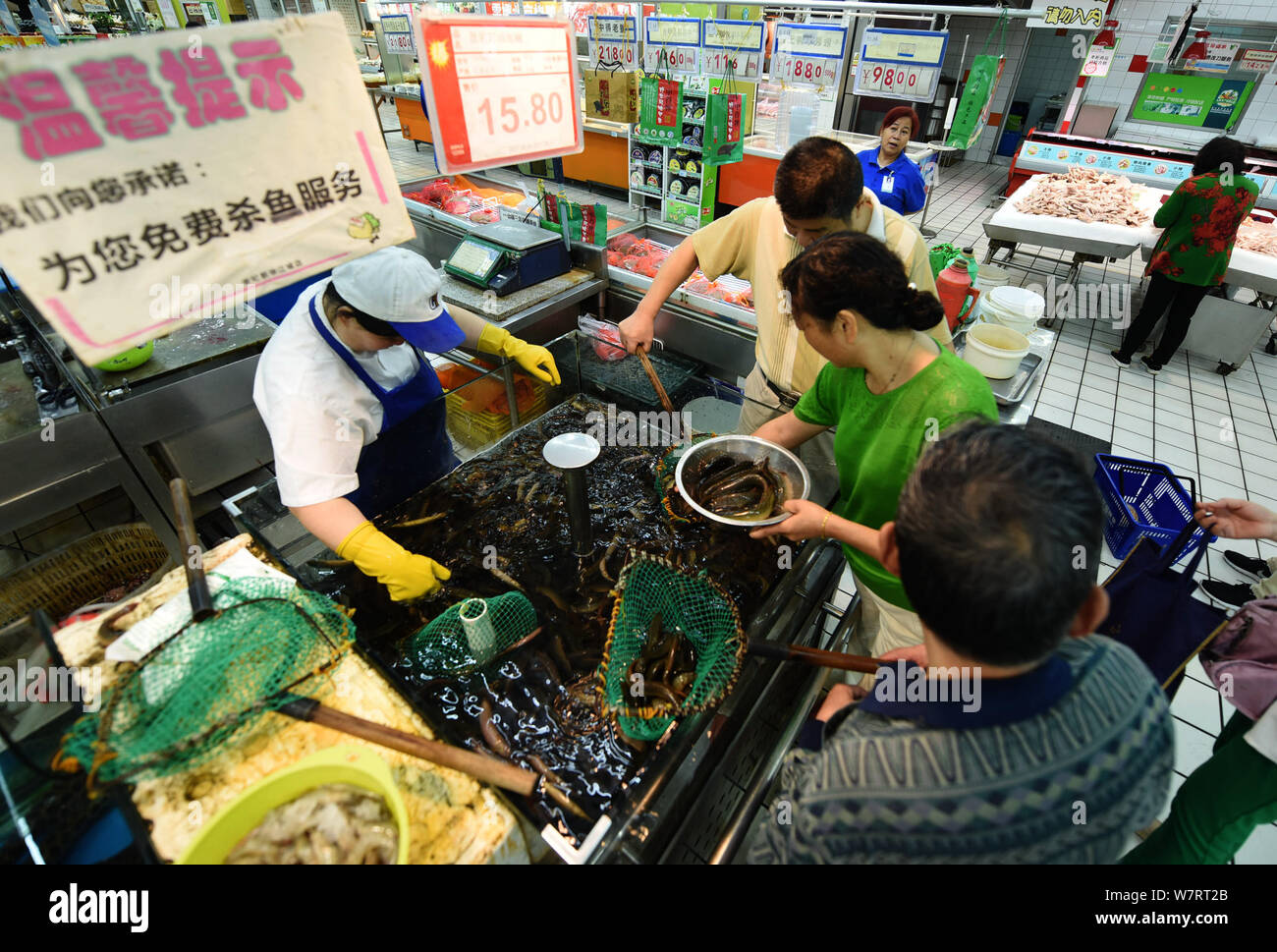 Customers shop for fish at a supermarket in Hangzhou city, east China's ...