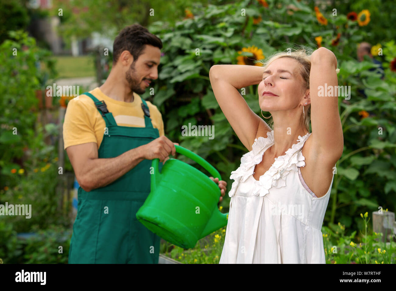 beautiful couple in the garden watering the flowers Stock Photo - Alamy