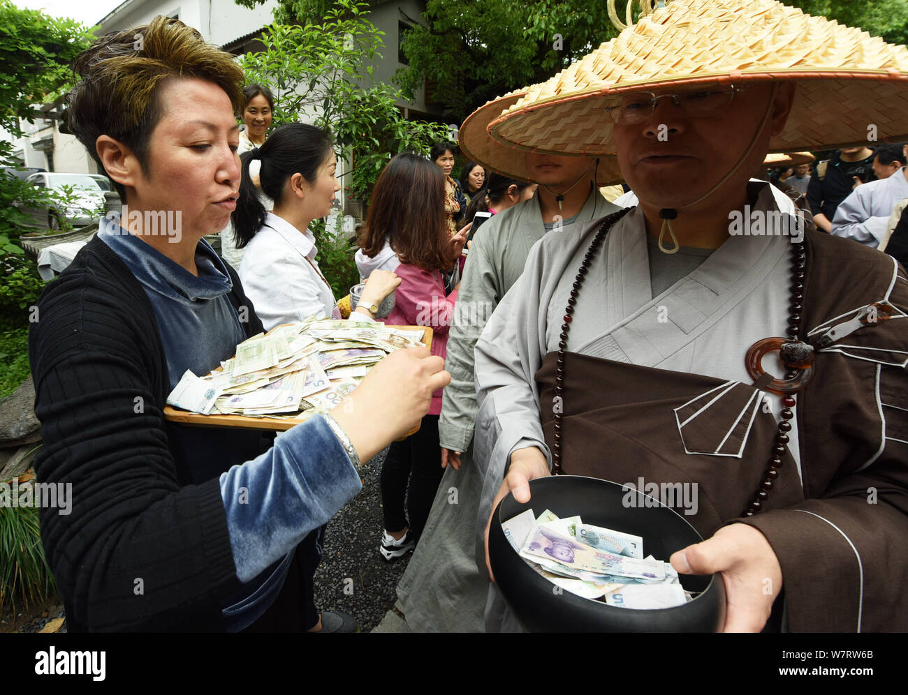 Chinese Buddhist monks holding alms bowls take part in a mendicants charity walk in Hangzhou ...