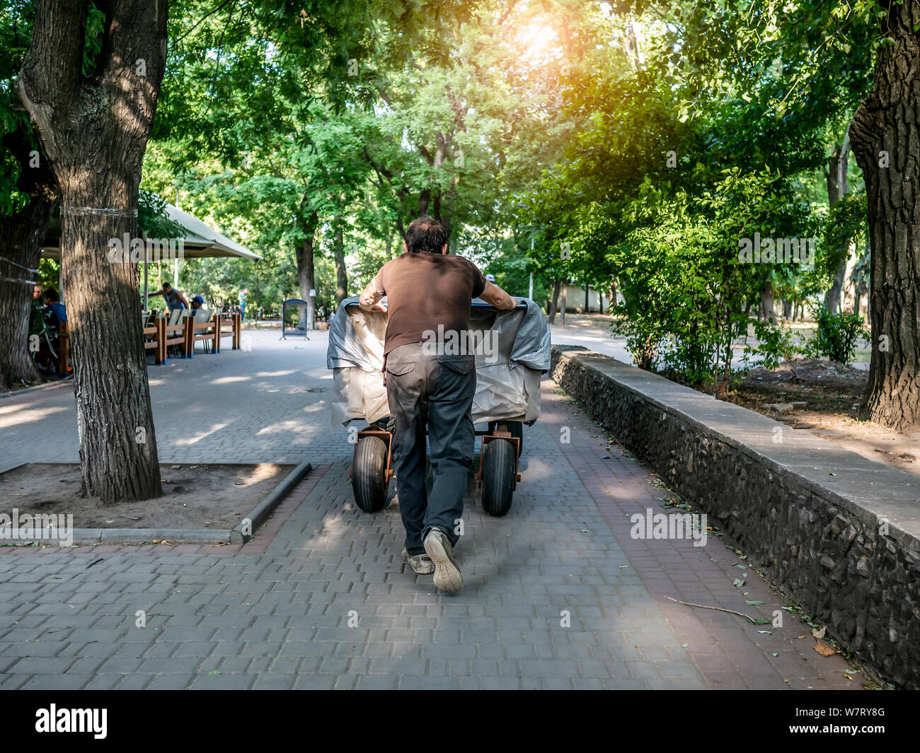a man pushes a cart in front of him Stock Photo - Alamy