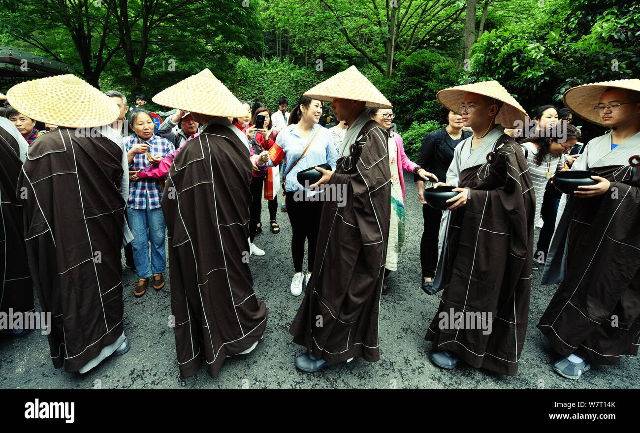 Chinese Buddhist monks holding alms bowls take part in a mendicants ...