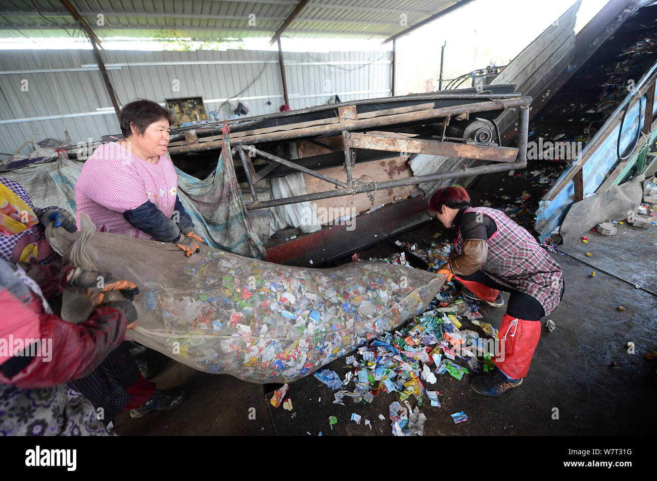 Chinese workers process plastic bottles at the plastic bottle recycling ...