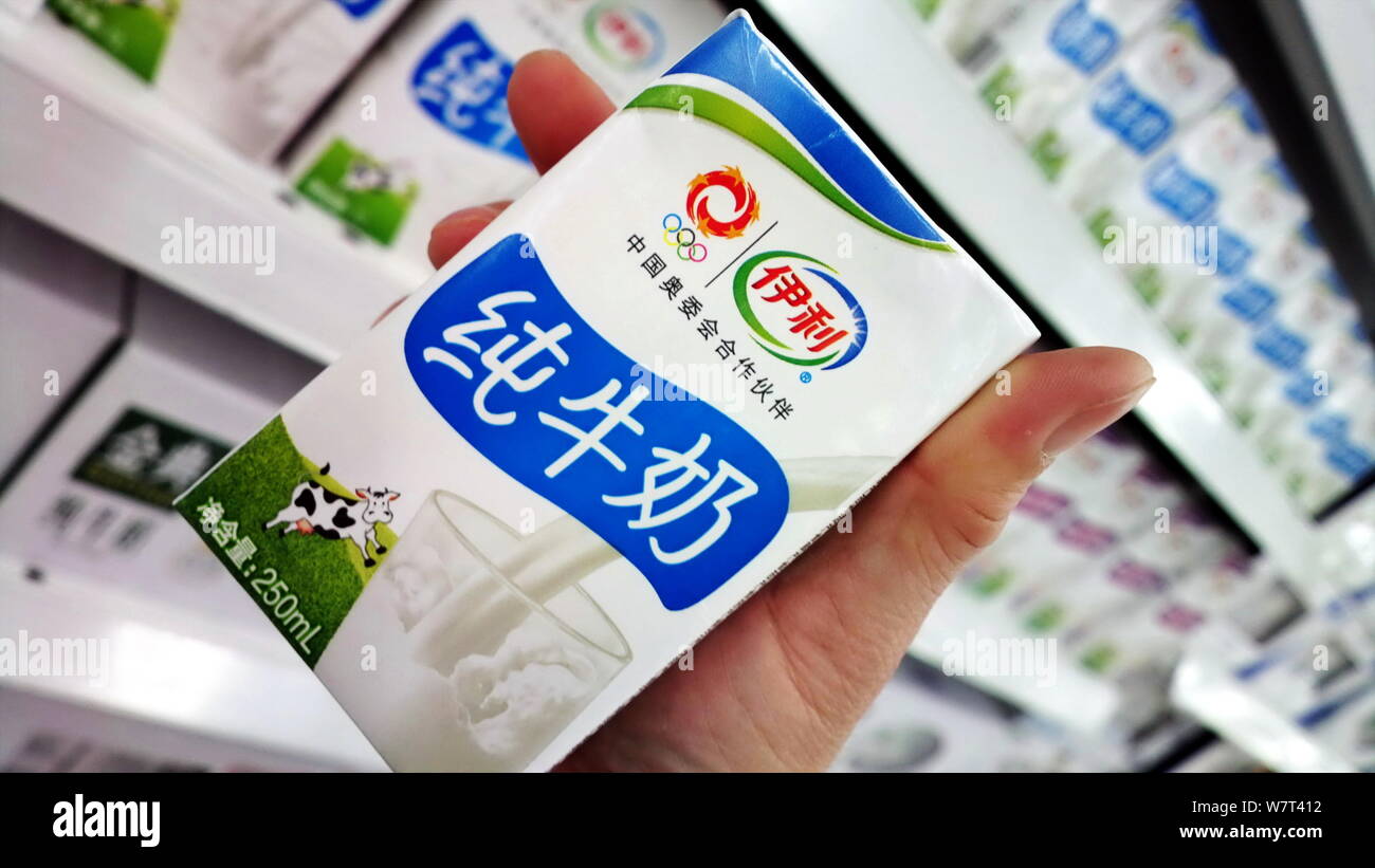 --FILE--A Chinese customer shops for a carton of Yili pure milk at a ...