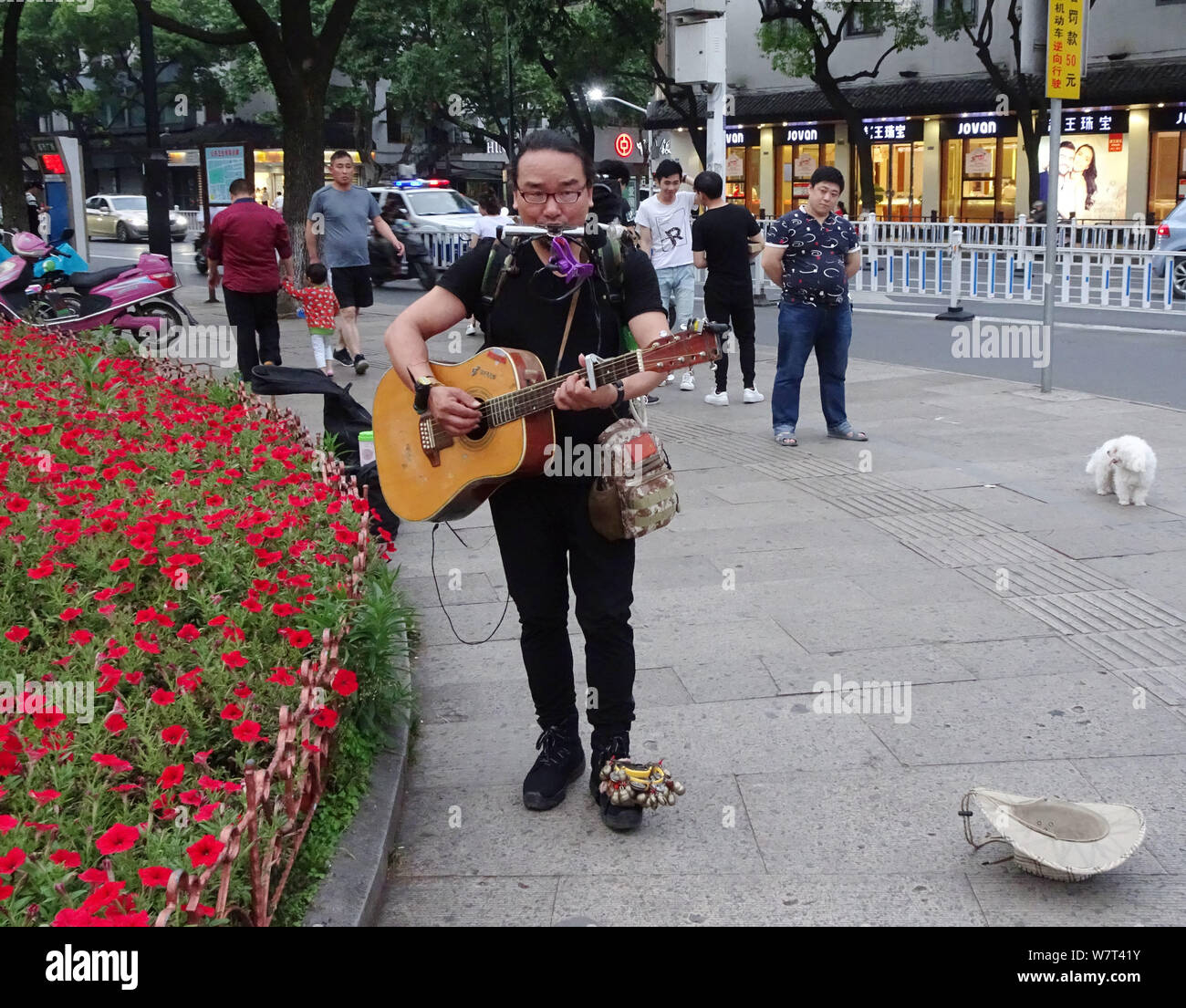 A street singer performs eight musical instruments simultaneously near ...
