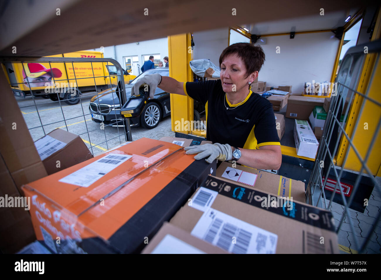 Wittenburg, Germany. 07th Aug, 2019. Parcel carrier Ute Eissing loads ...
