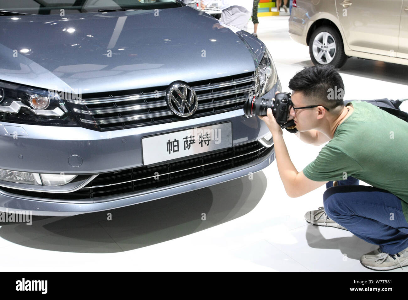--FILE--A visitor takes photos of a Passat of Shanghai Volkswagen, a ...