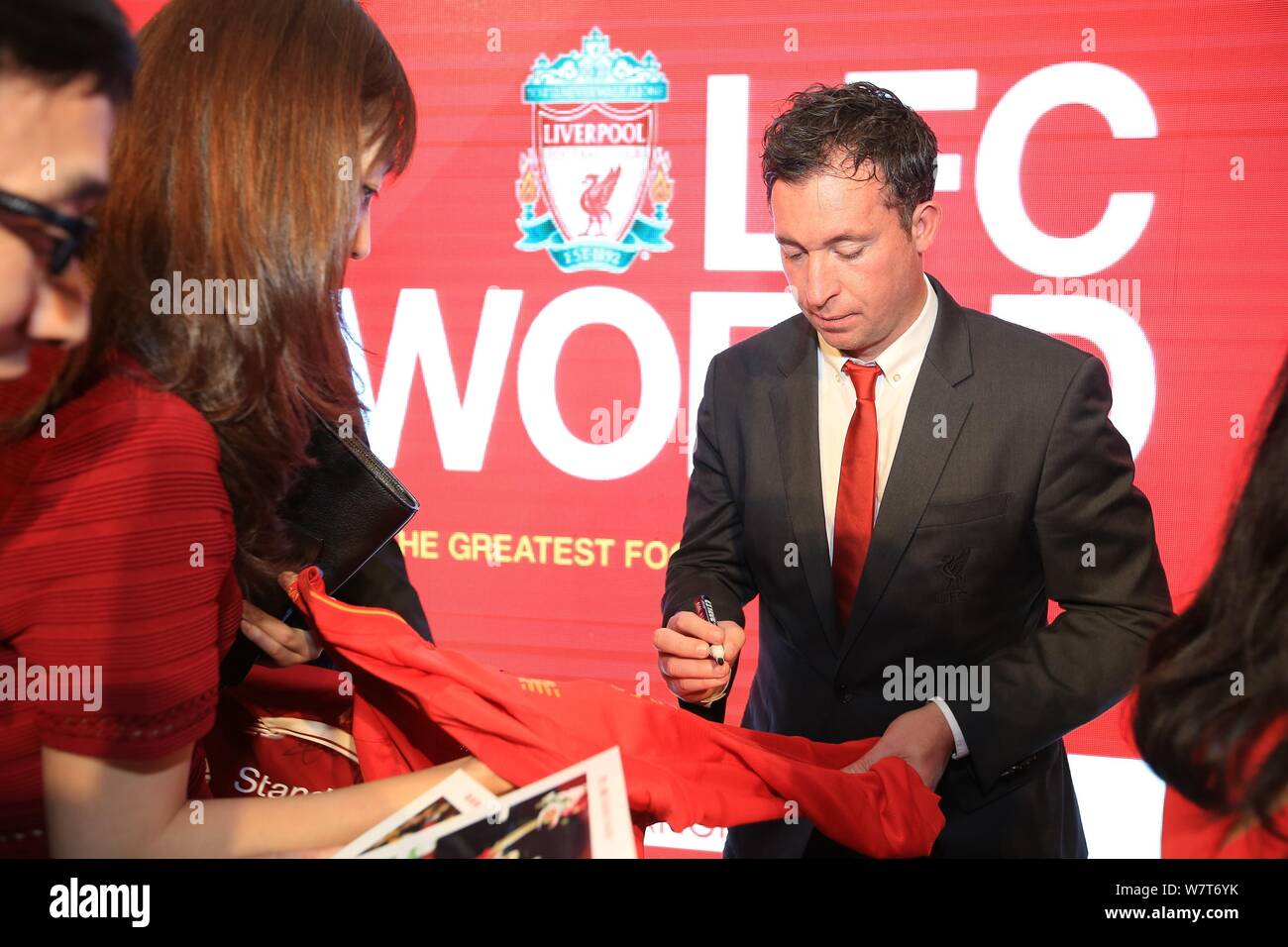 Retired Liverpool soccer star Robbie Fowler signs an autograph for fans ...
