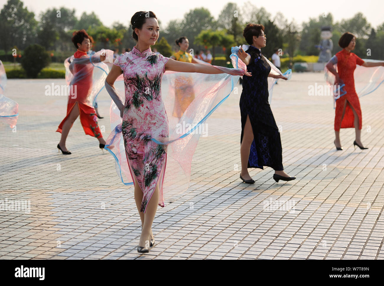 Women present cheongsam, a traditional Chinese women's dress also known ...