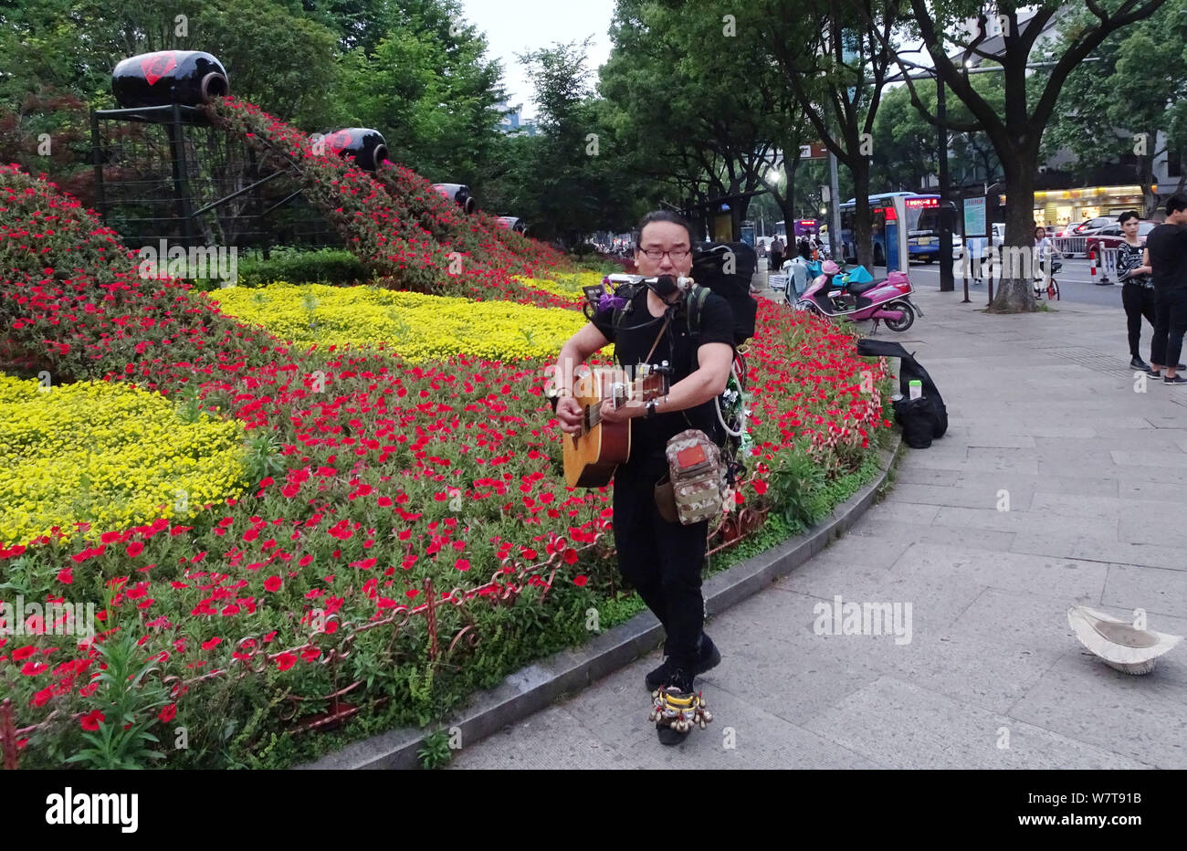 A street singer performs eight musical instruments simultaneously near ...