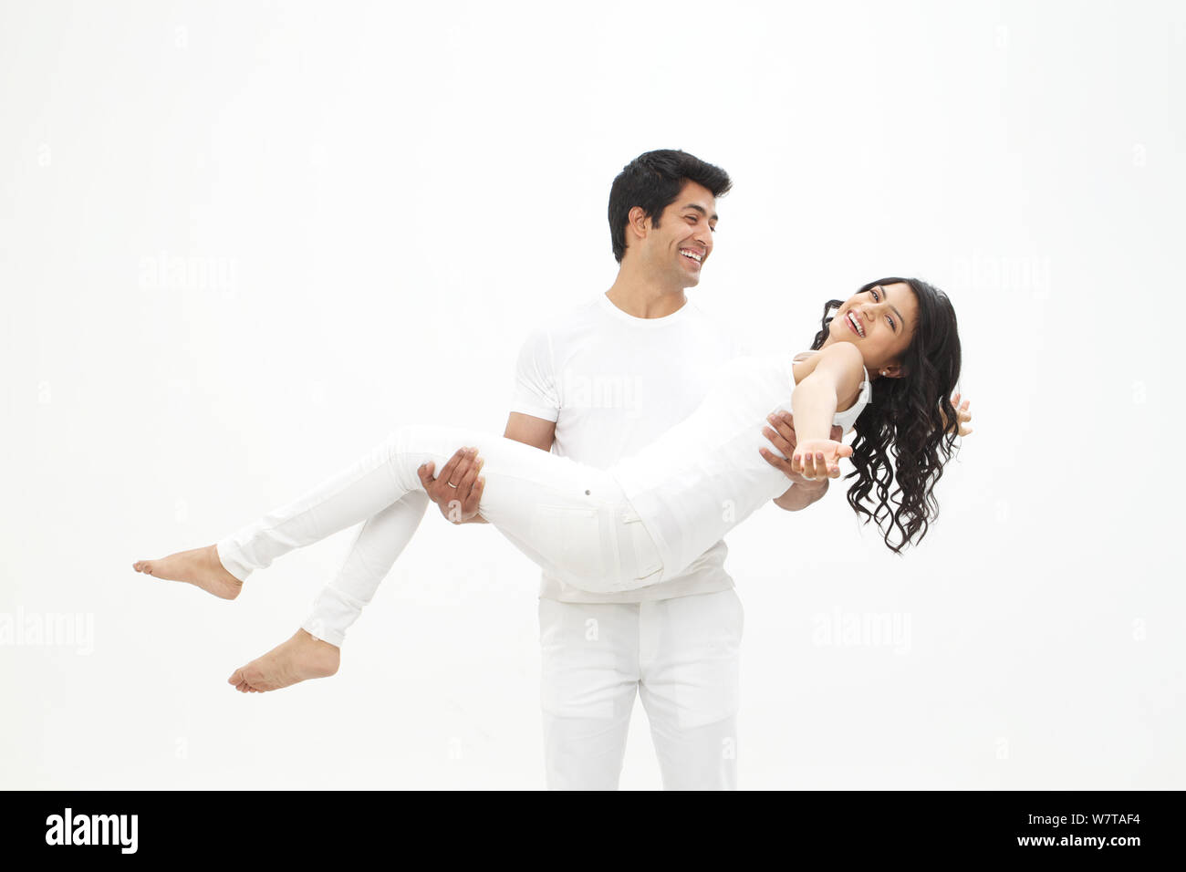 Young man carrying his girlfriend isolated on white background Stock ...